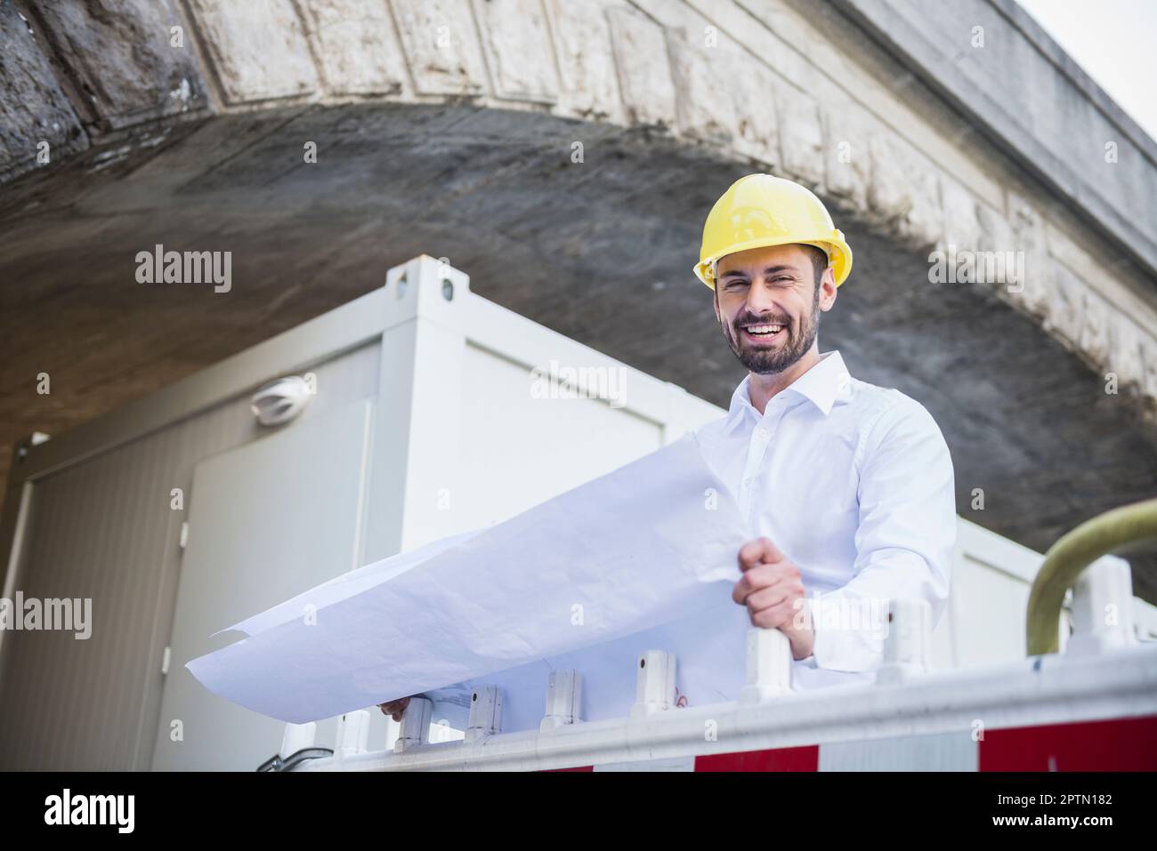 Male architect reading blueprint at construction site, Munich, Bavaria ...