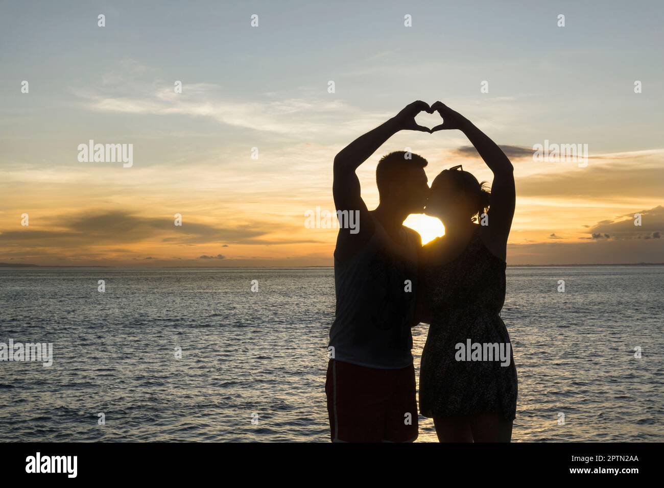 Silhouette of couple making heart shape with hands, Nusa lembongang ...