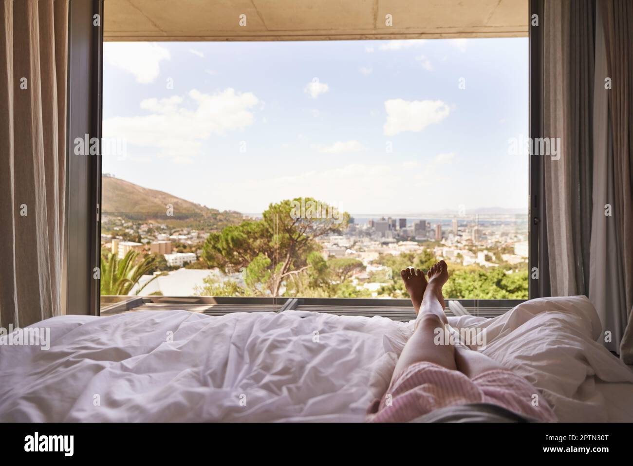 The best view in the building. a woman lying in bed with a view from ...