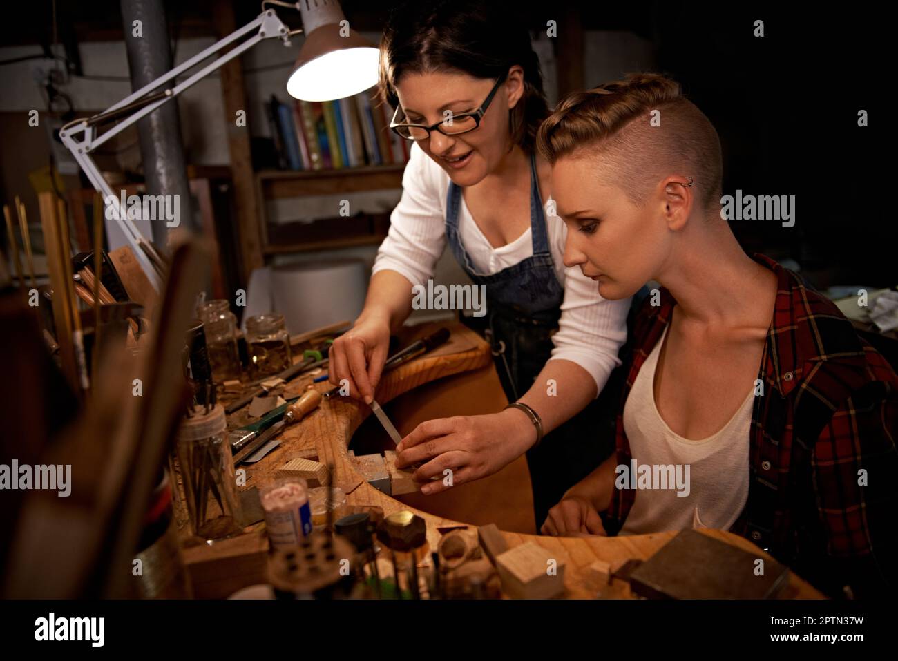 Making something beautiful together. two young woman working on ...