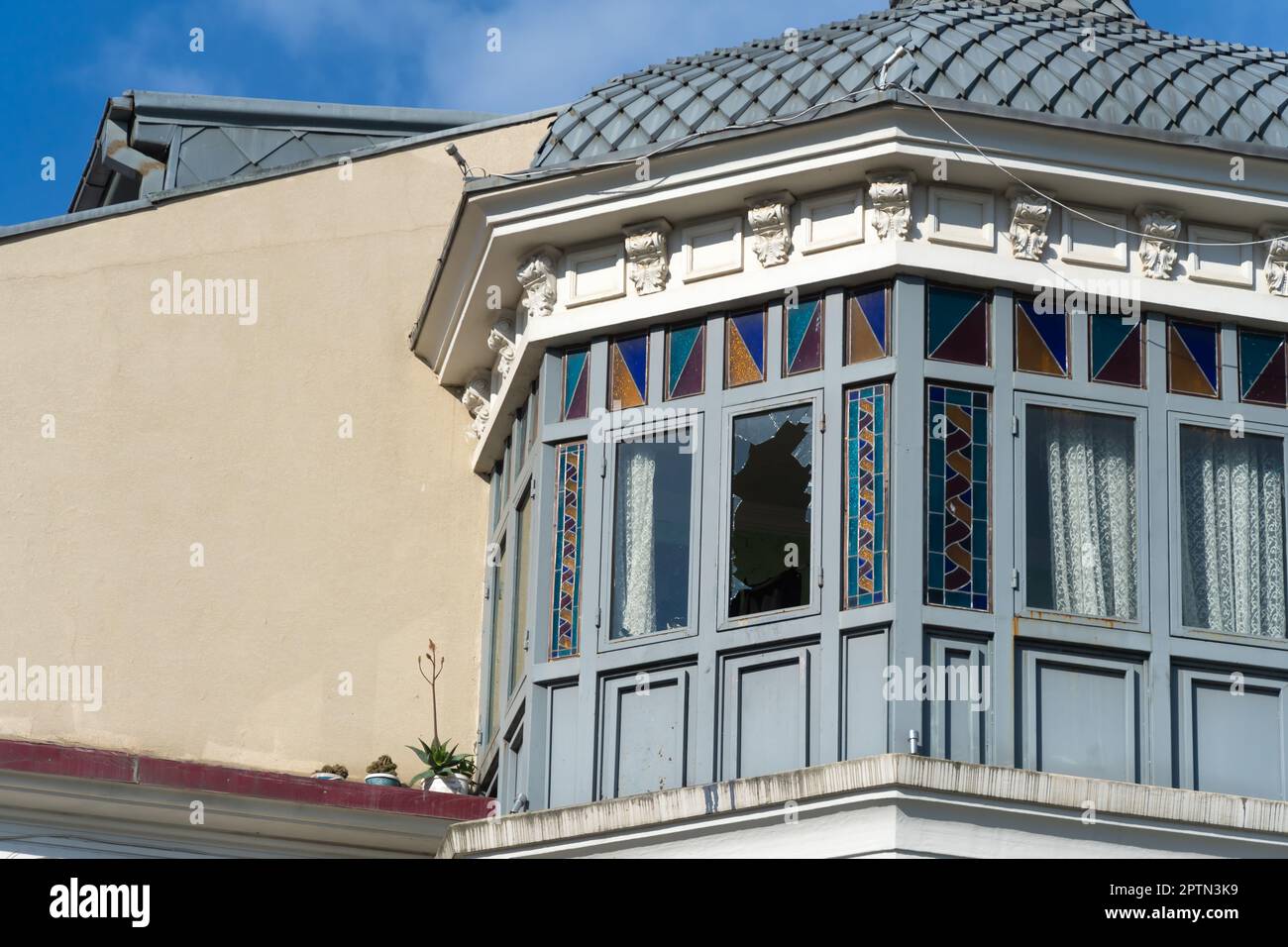 Close-up of a broken window on the beautiful facade of a balcony with ...
