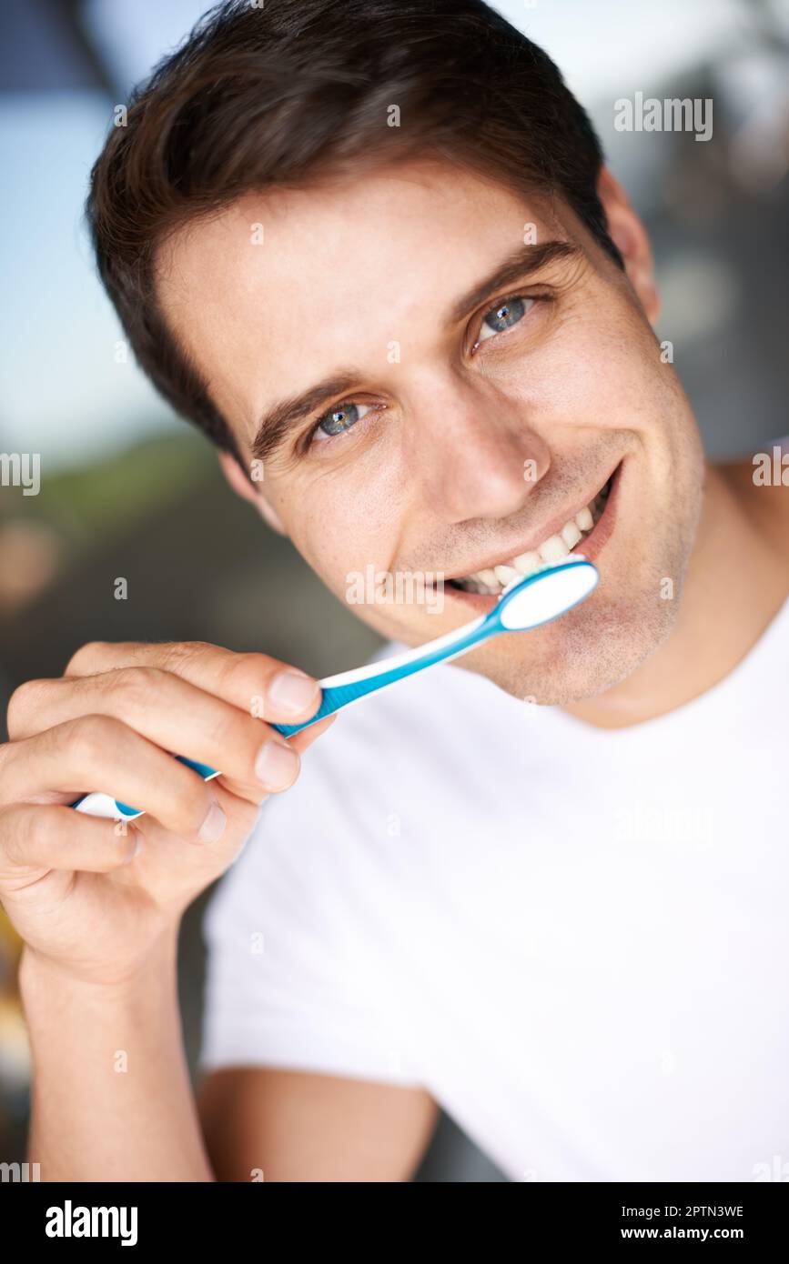Practicing good dental hygiene. Closeup of a young man brushing his ...