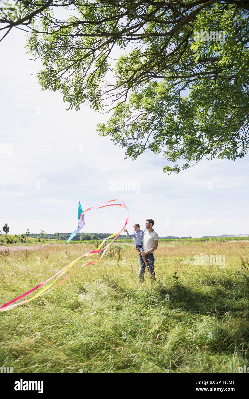 Father and his son flying kite in the countryside, Bavaria, Germany ...