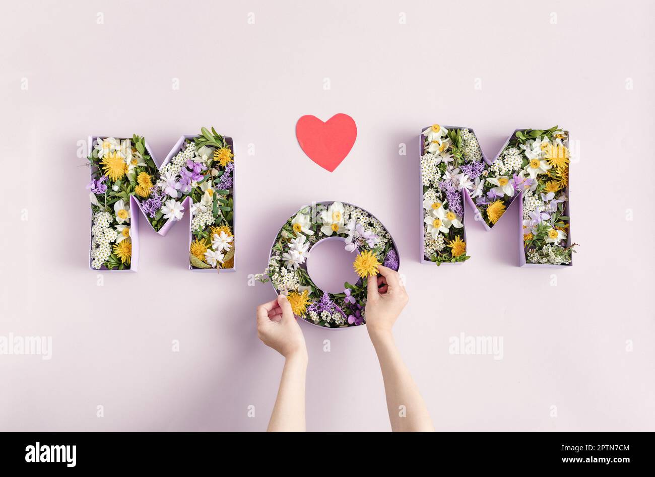 paper boxes in shape of MOM word filled with flowers by girls hands ...