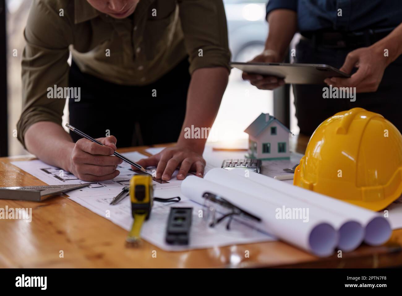 Architect and Engineer working with blueprints for architectural plan ...