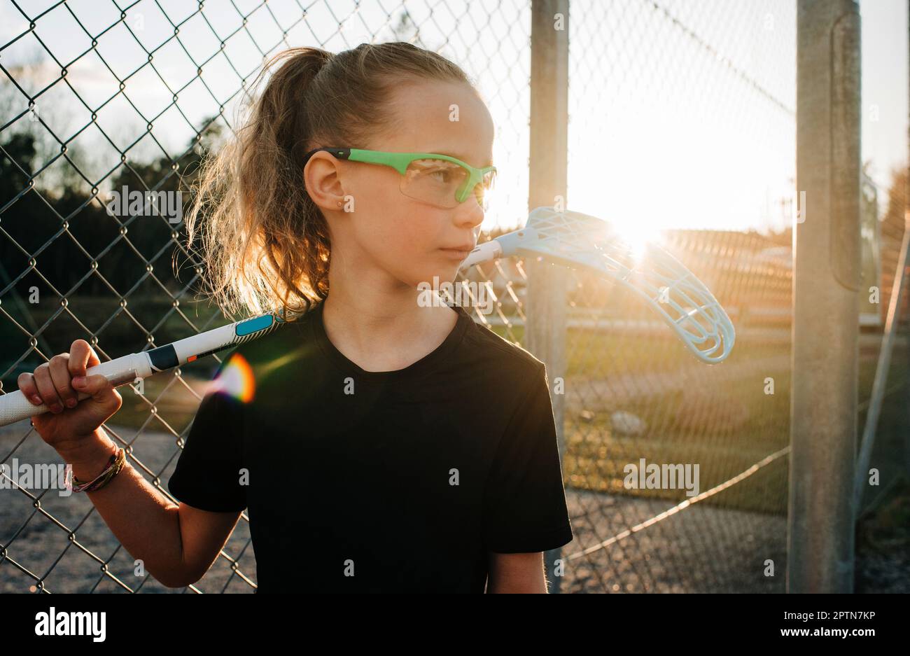 Girl holding a innebandy stick waiting to play a game at sunset Stock ...