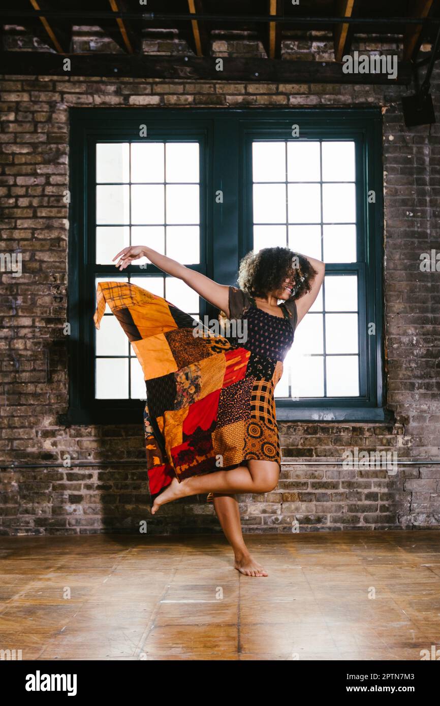 Female curly hair dancer smiles while moving and dancing Stock Photo ...