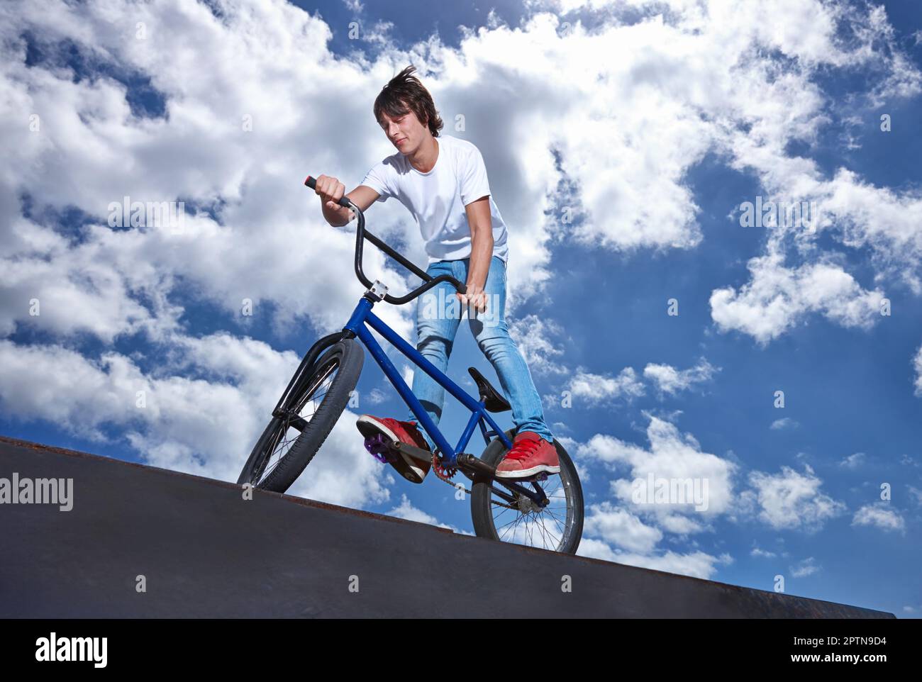 Practicing for the x games. a teenage boy riding a bmx at a skatepark ...