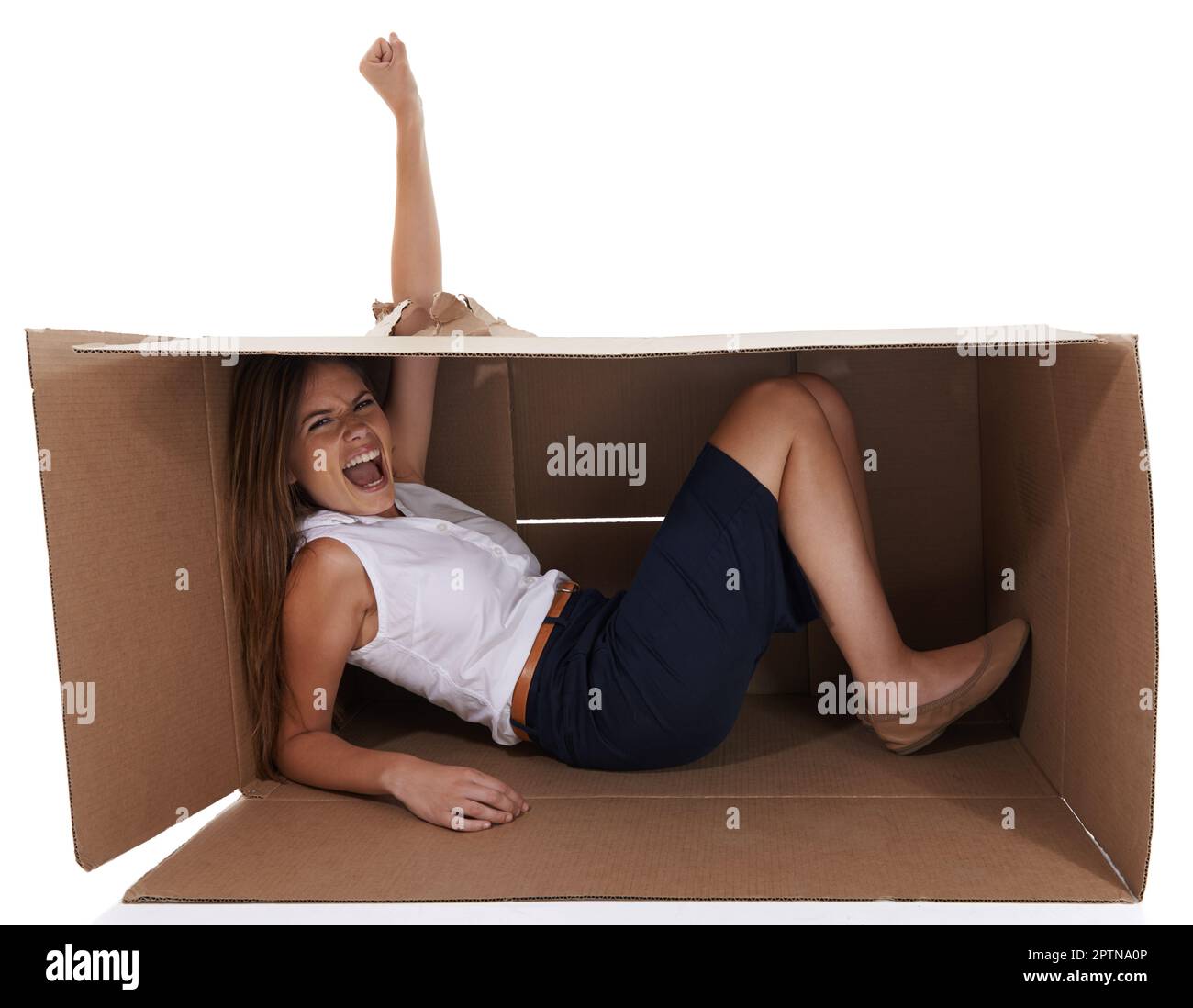 Im breaking outta here. A young woman breaking through a cardboard box ...
