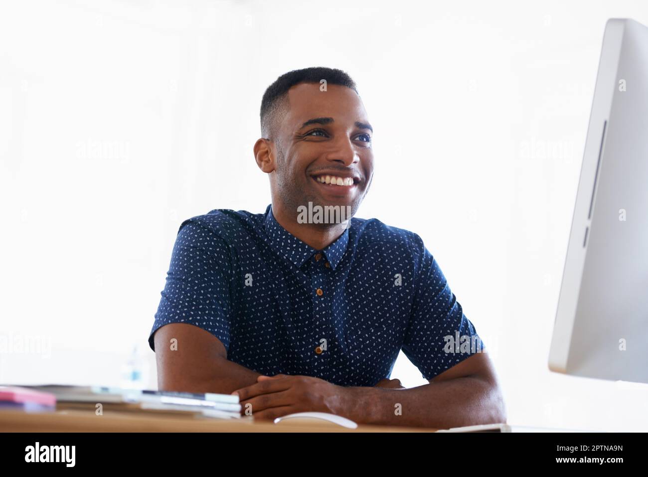 Working his way up the corporate ladder. An African-American man working on his computer Stock ...