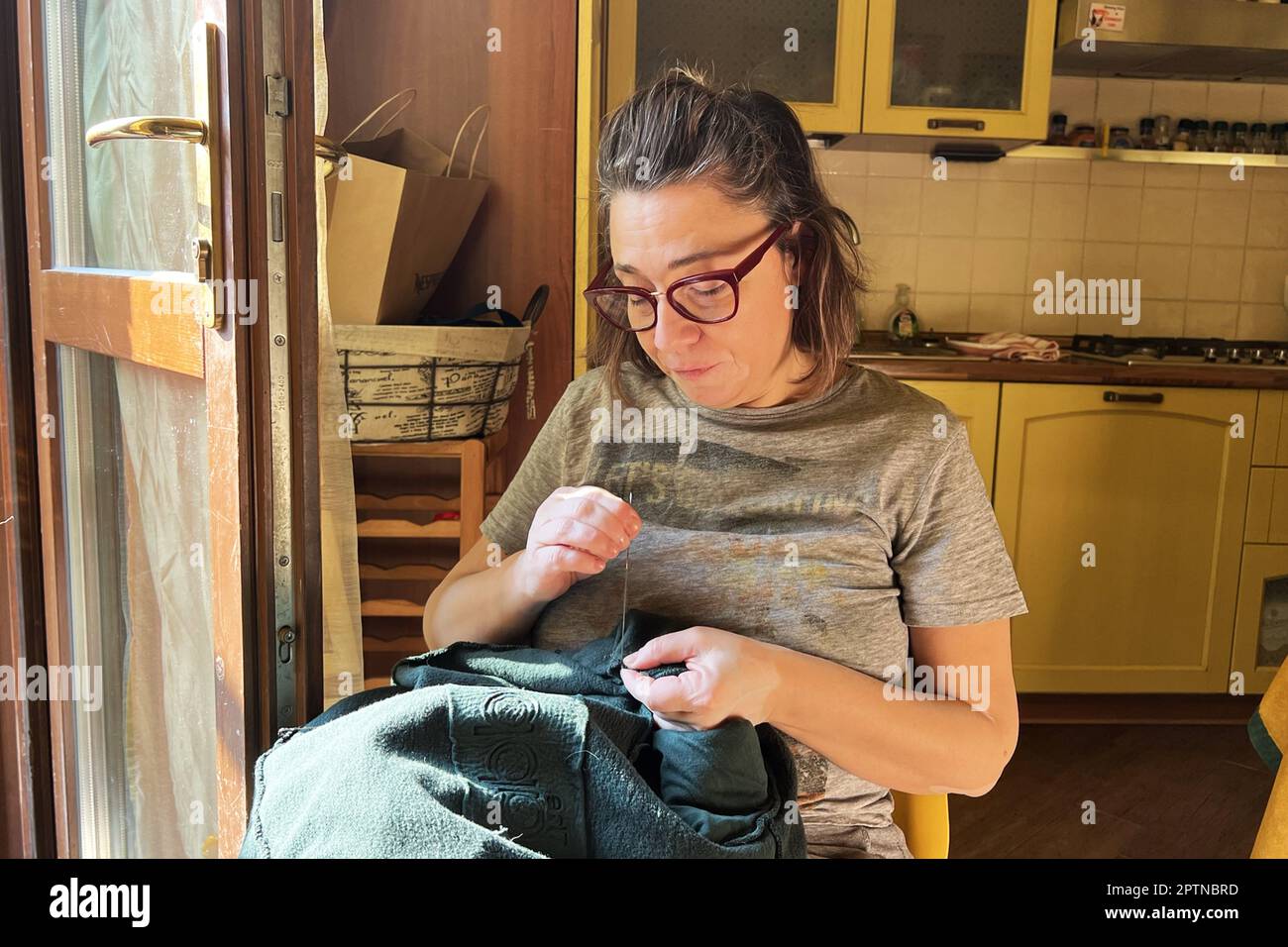 Woman mending clothes Stock Photo - Alamy