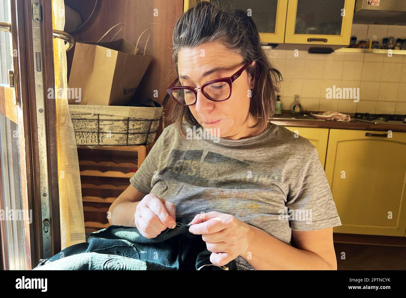 Woman mending clothes Stock Photo - Alamy