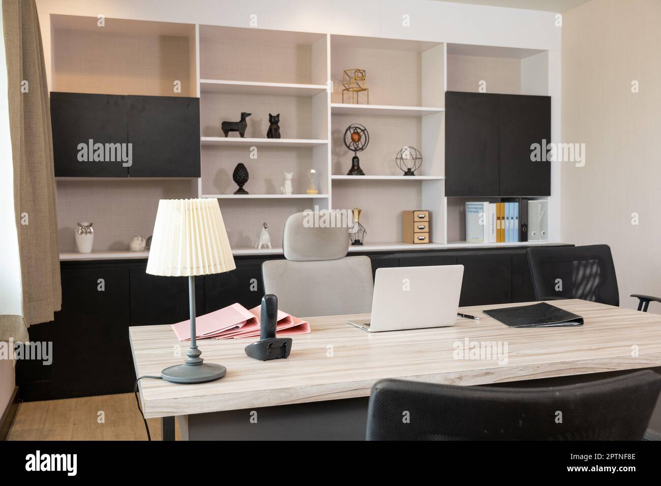 Comfortable office chair near wooden table with laptop computer ...