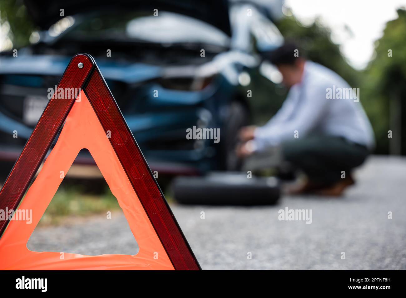 Asian businessman car broken has problems with wheel of his car during ...