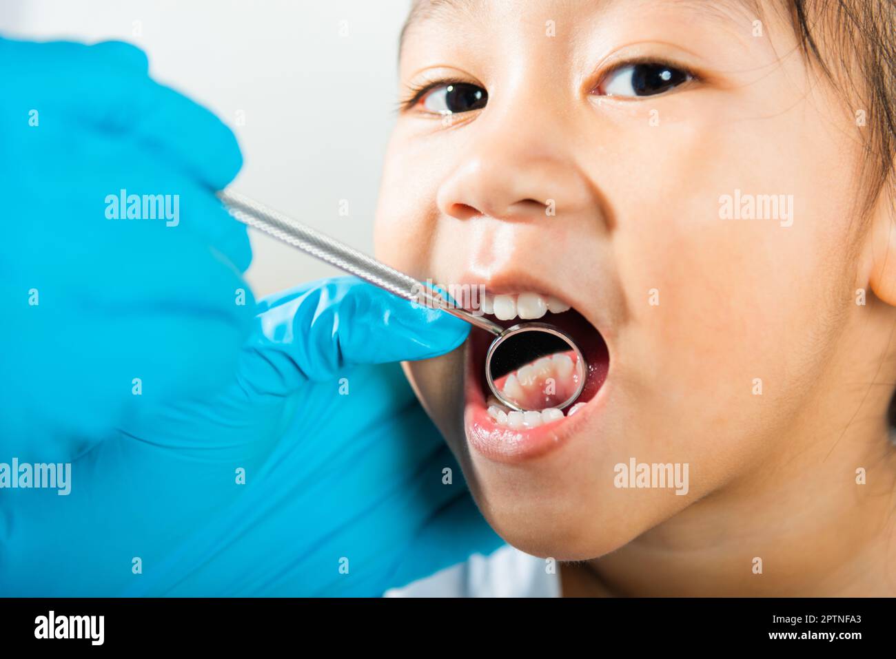 Dental kid health examination. Doctor examines oral cavity of little ...