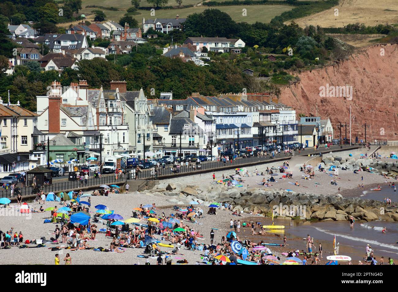 Tourists relaxing on the beach with views towards town buildings and ...