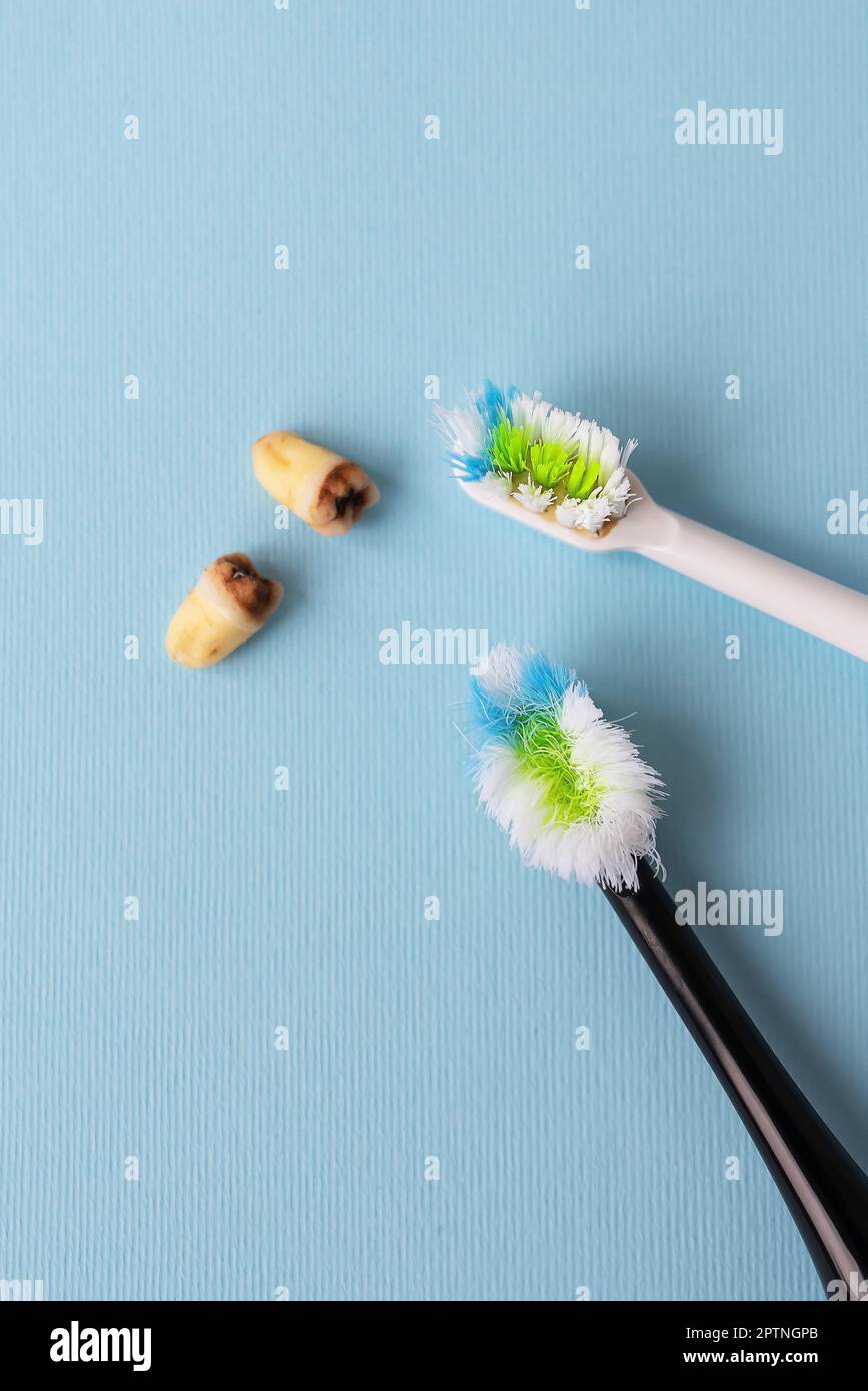 A modern electric toothbrush on a blue background next to extracted ...