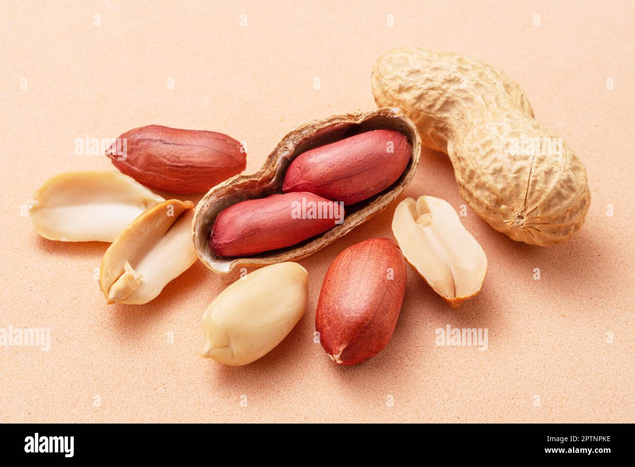 Peanuts whole and cracked isolated on beige background Stock Photo - Alamy