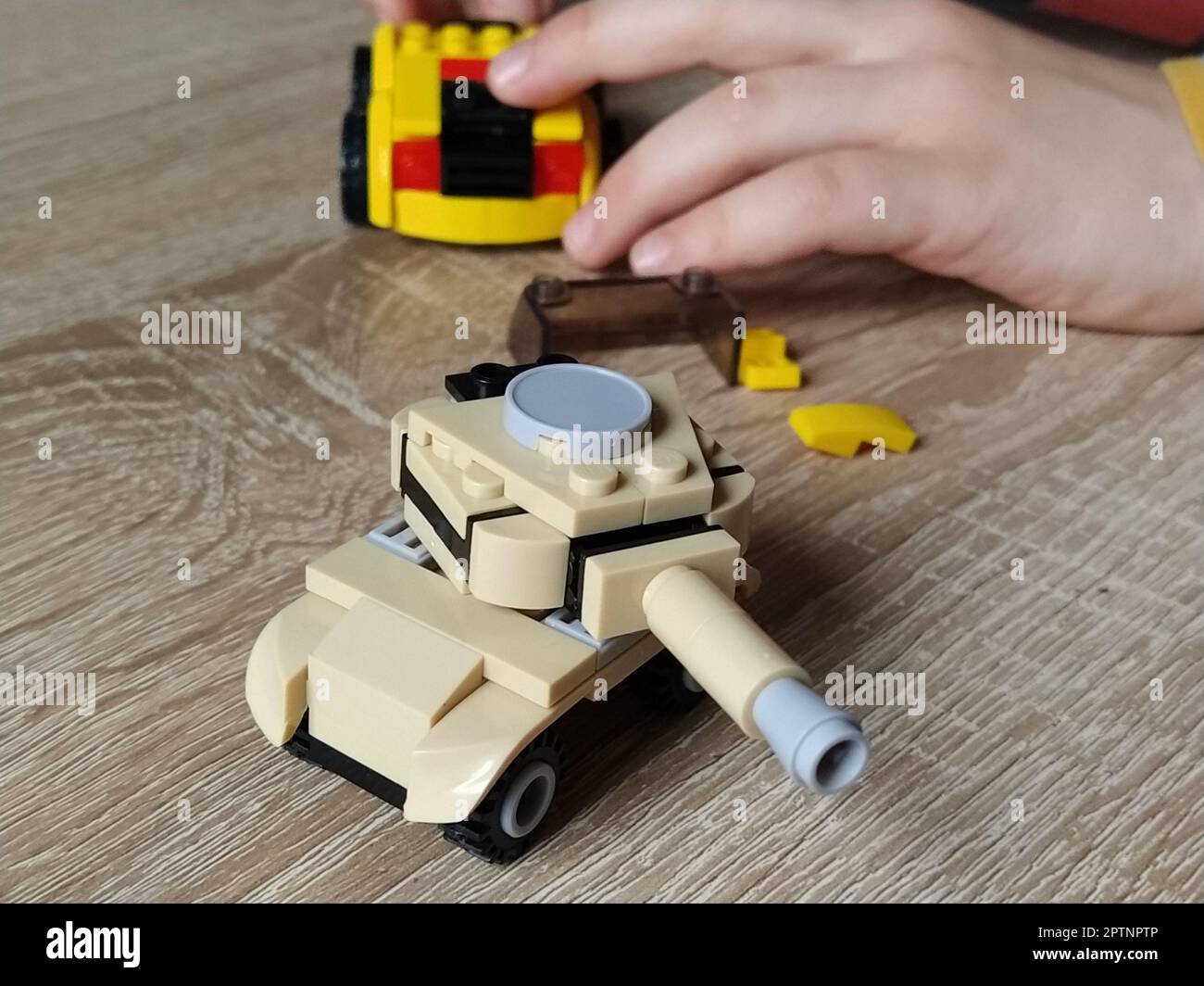 Toy tank on a wooden table. Plastic toy. Craft from a childrens ...