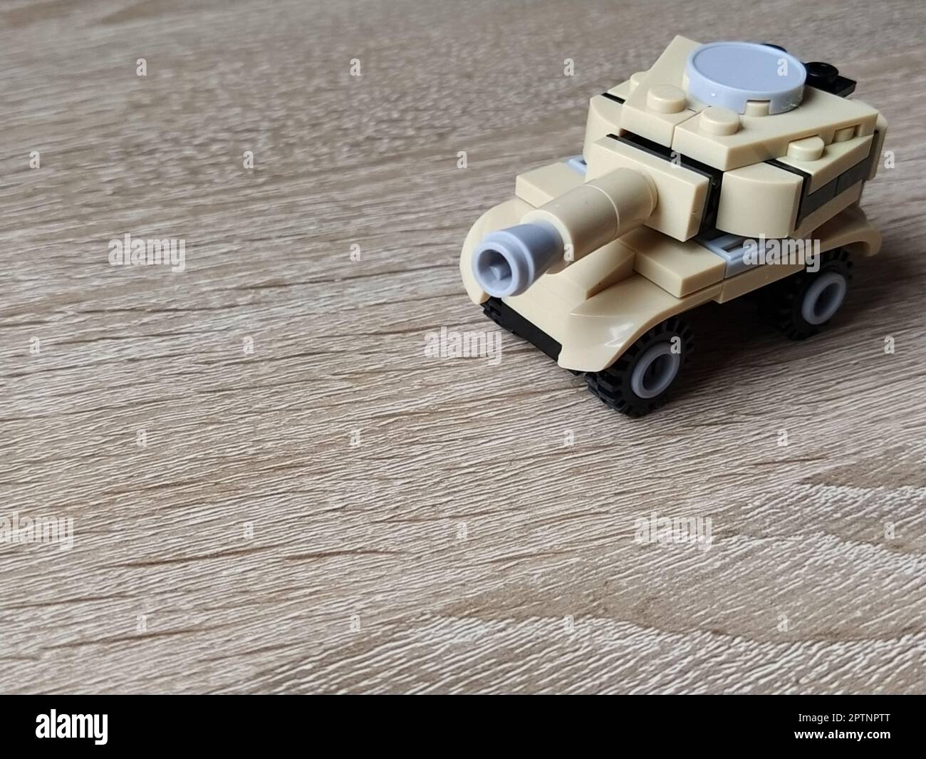Toy tank on a wooden table. Plastic toy. Craft from a childrens ...