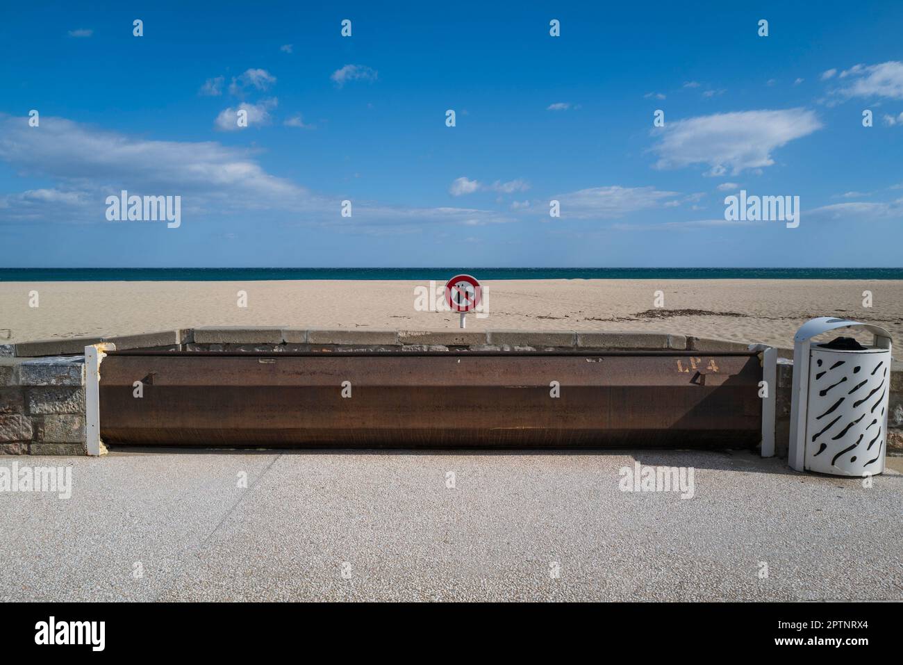 Sand barrier at the exit of the beach with a sign prohibiting access to ...