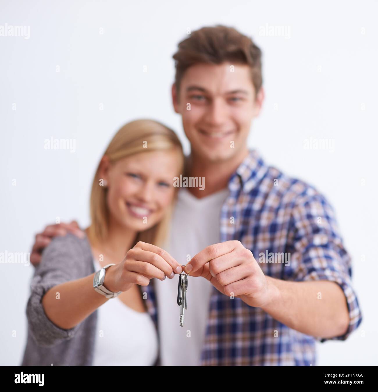 This is the moment. A young couple holding the keys to their new ...