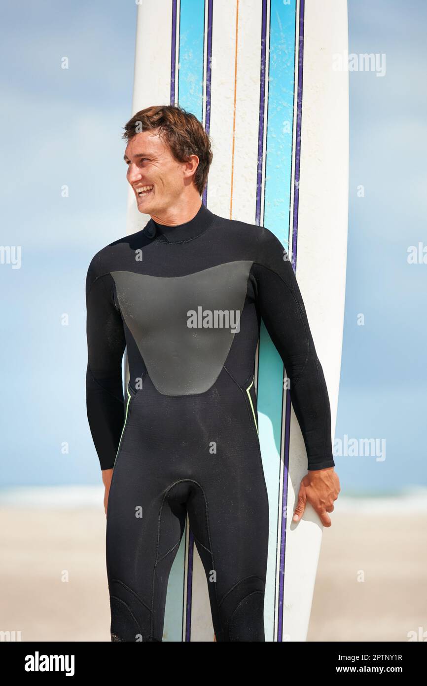 Its just me and my surfboard. a handsome surfer standing at the beach ...