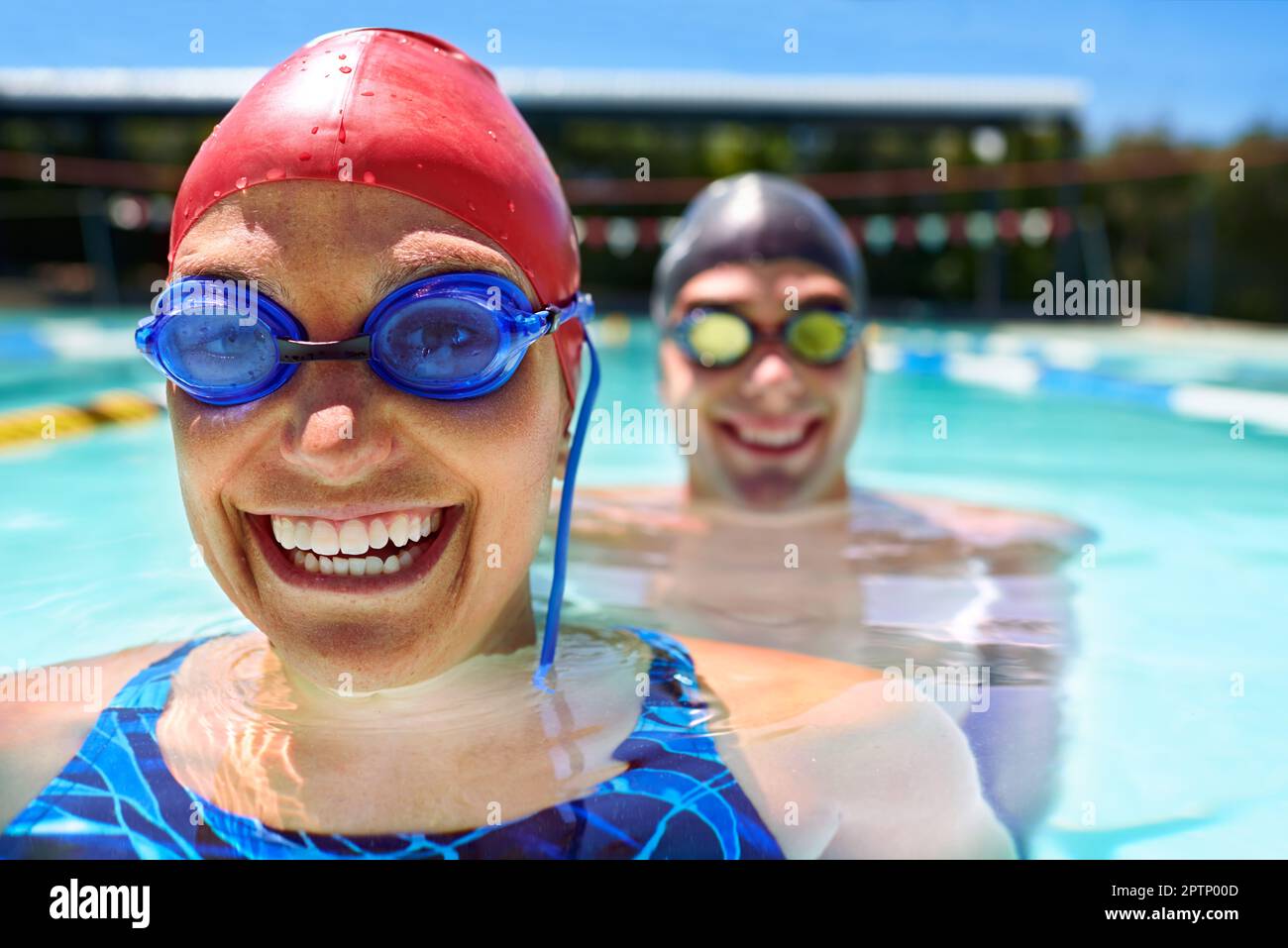 Ready For A Swim A Man And Woman Standing In A Pool Wearing Goggles