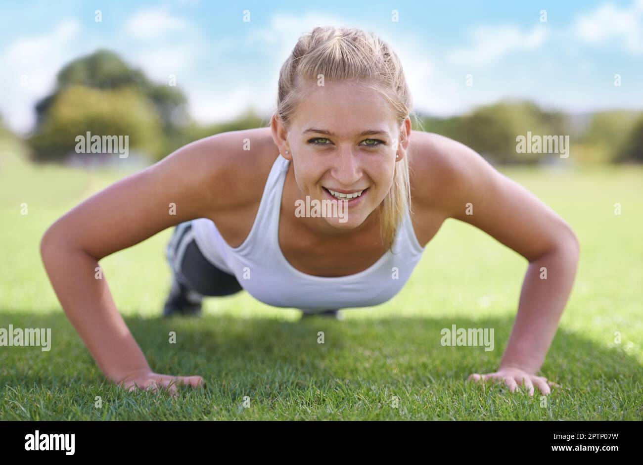 Fit and confident. an attractive young woman doing pushups outside ...