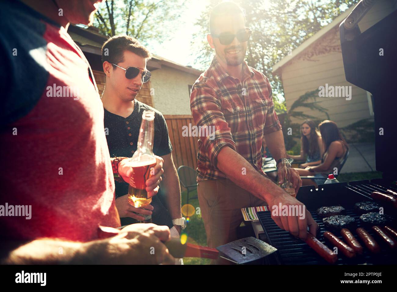 Having a barbecue with his buddies. a group of friends having a ...