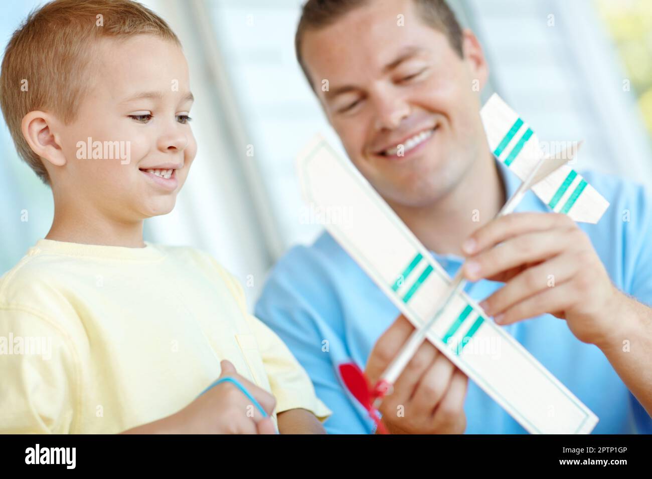 Finishing up the model airplane building process. Young father showing ...