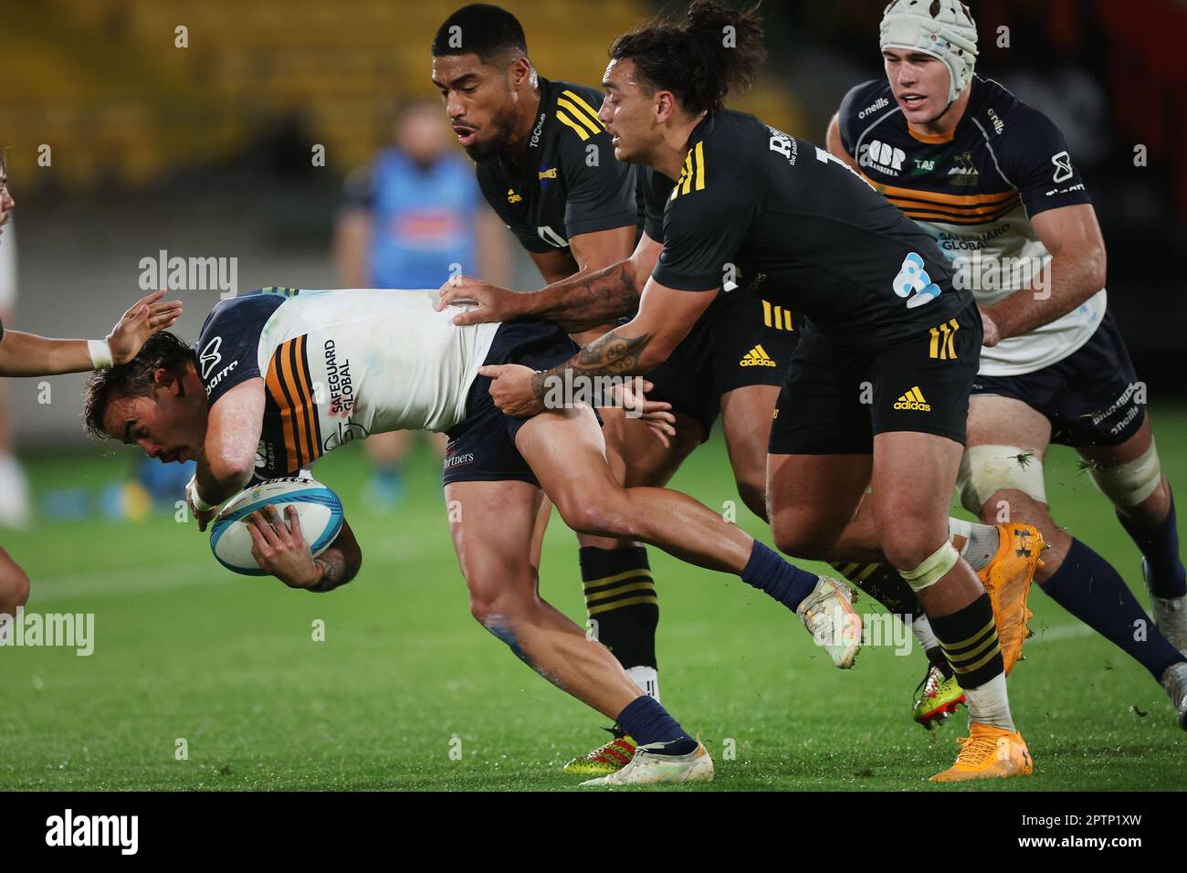 Brumbies' Andy Muirhead (L) with Hurricanes Peter Umaga-Jensen (R) and ...