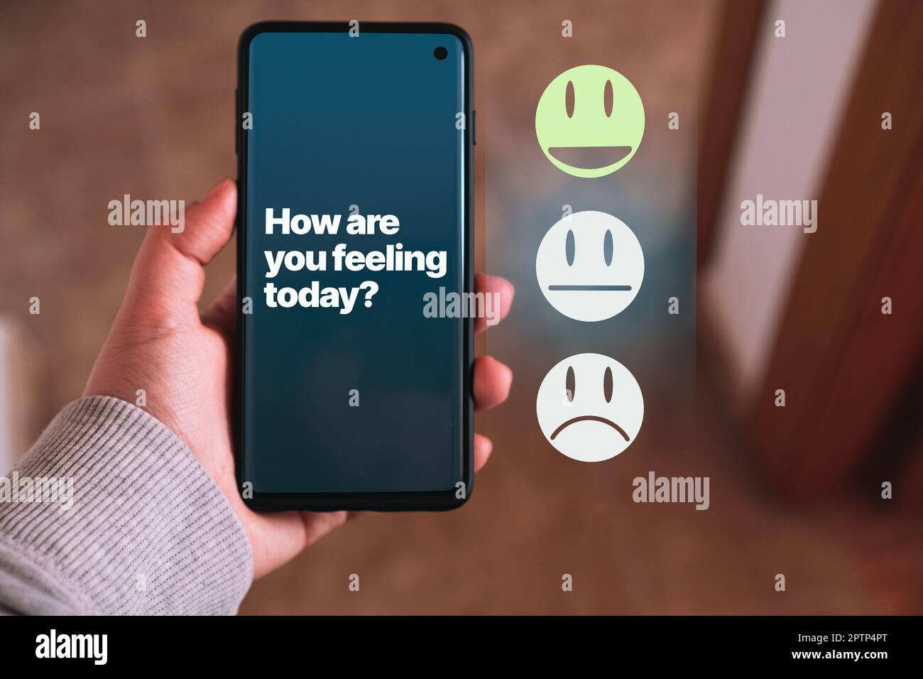 Woman's hand holds a smartphone while choosing a smile happy face on ...