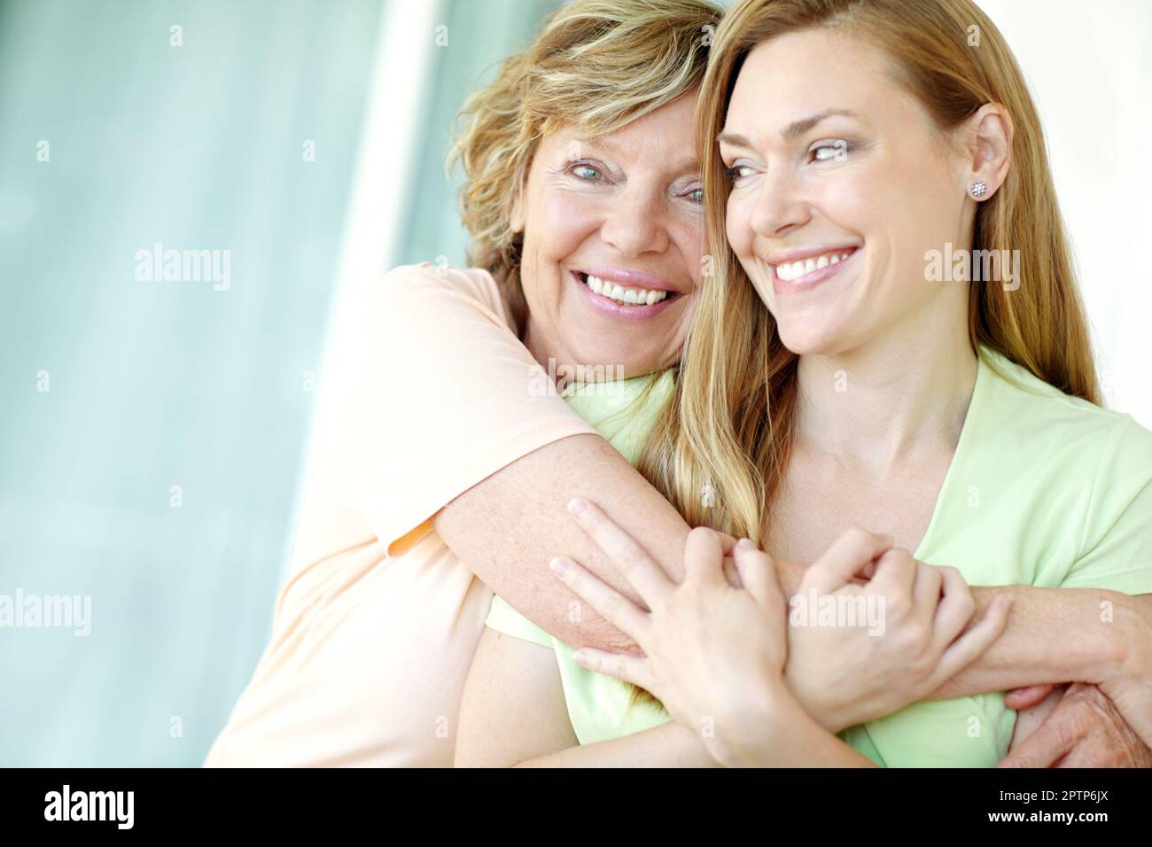 Receiving a big hug from mom. A beautiful woman receiving an ...