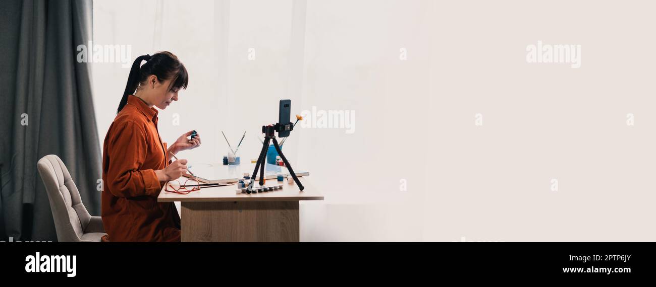 Caucasian woman watching stream learning how to draw with acrylic paint ...
