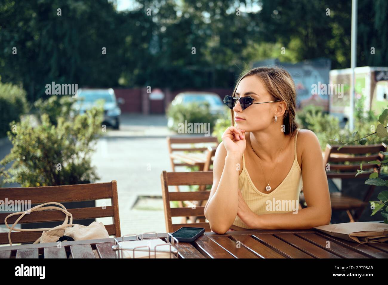 Young woman waiting for her friends at outdoor cafe terrace Stock Photo ...