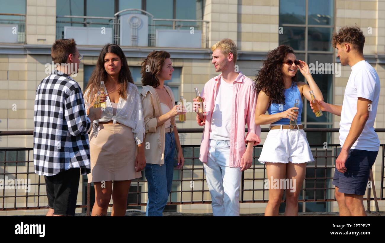 Friends standing rooftop talking clinking hi-res stock photography and ...