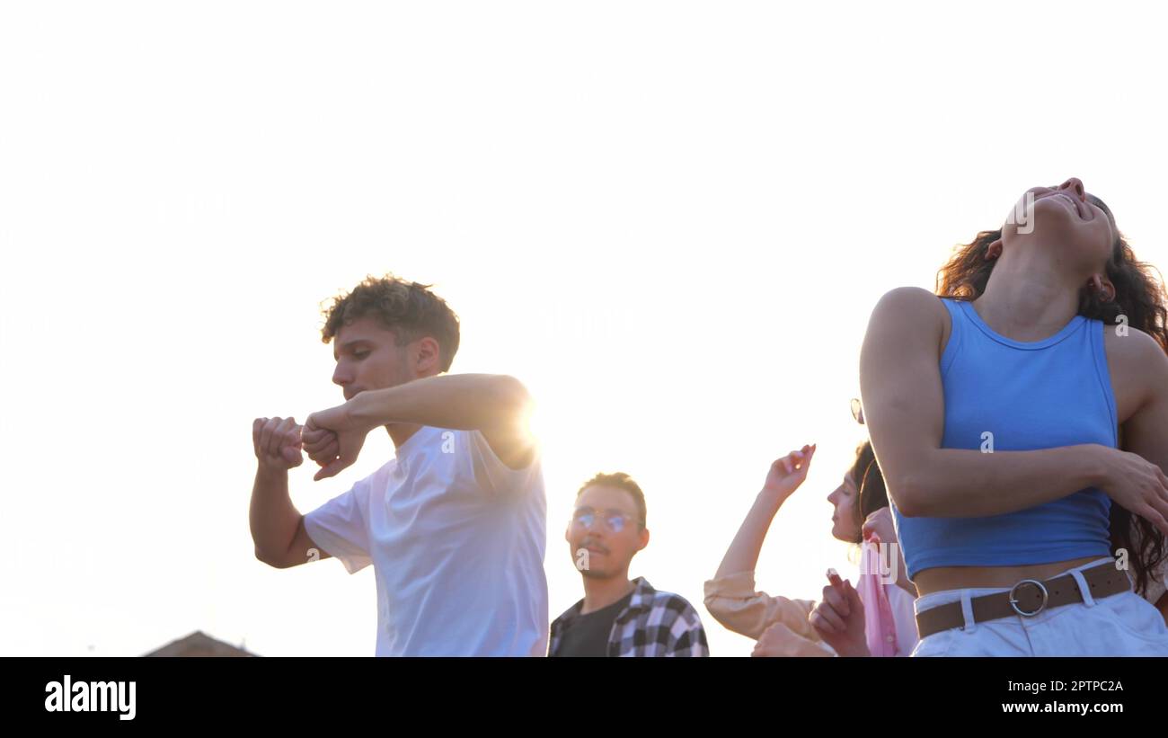 Joyful positive youth dancing at a party during daytime having fun ...