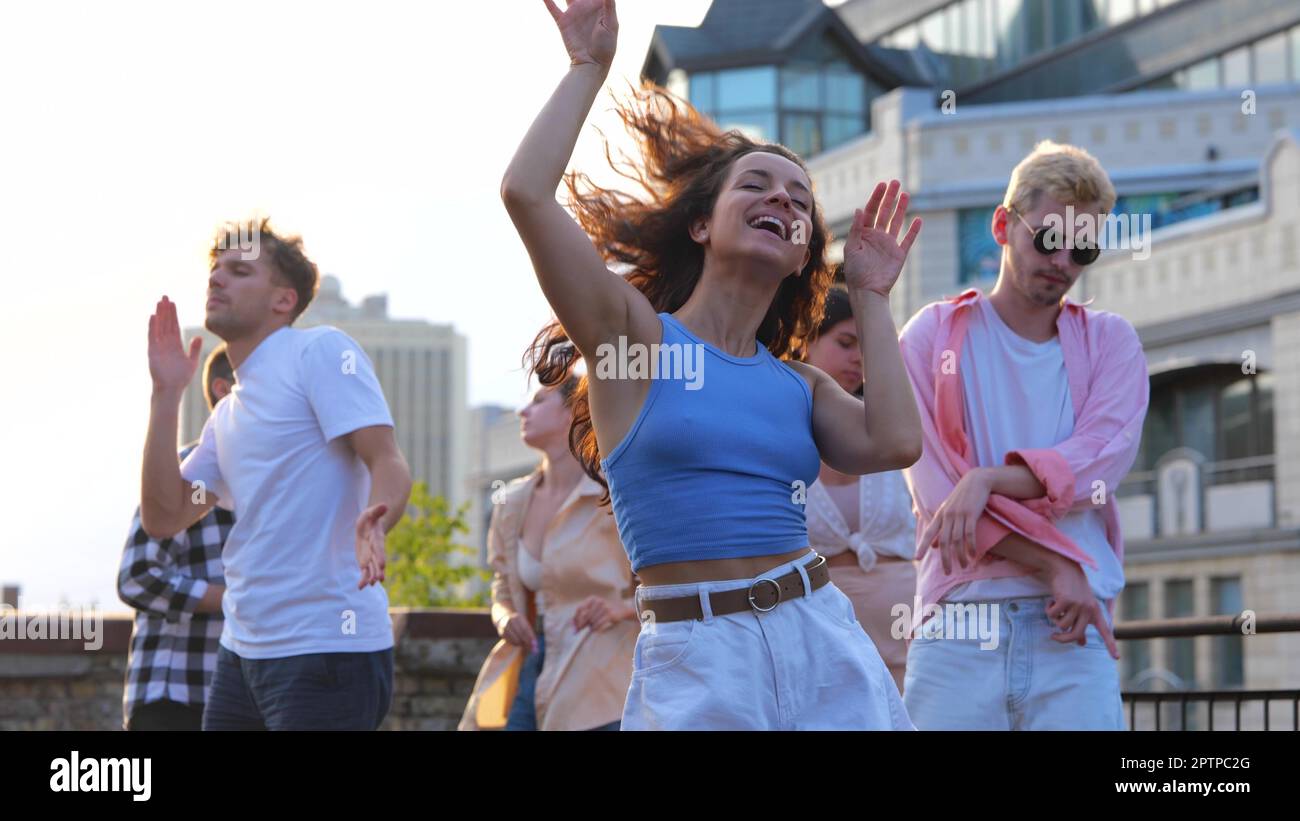 Happy young people dance on a roof having fun together. Caucasian ...