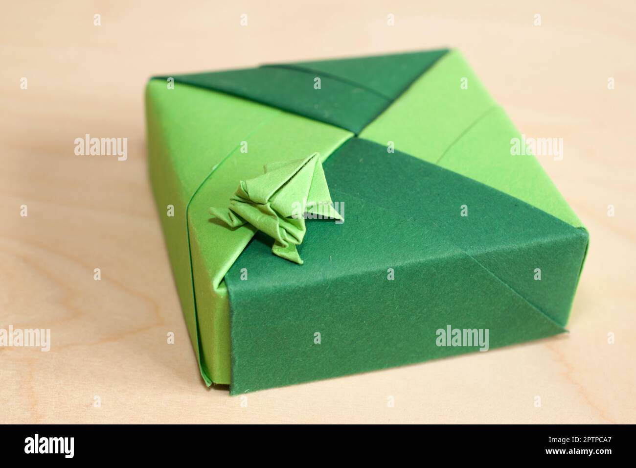Green origami frog on top of origami box lid Stock Photo - Alamy