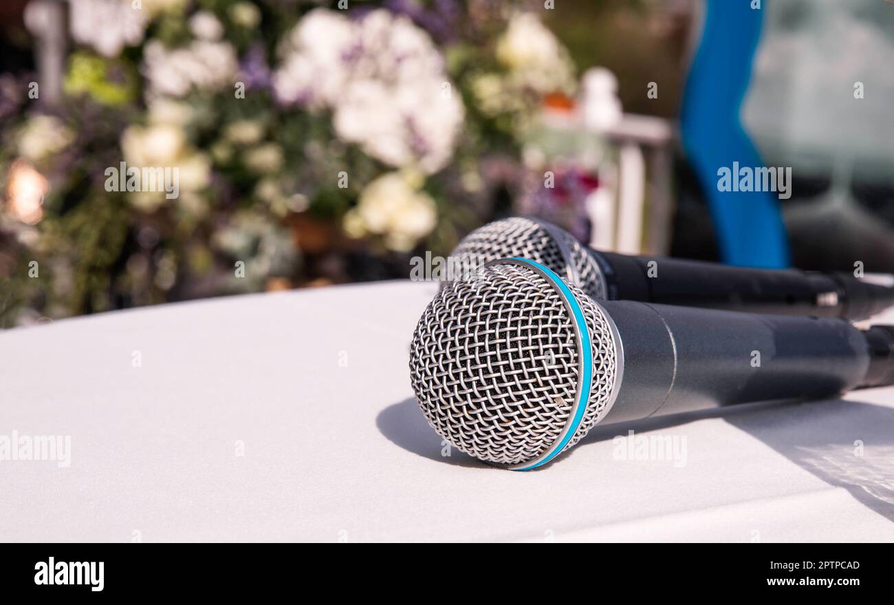 Two microphones lying on a table. Public speaking, performing Stock ...