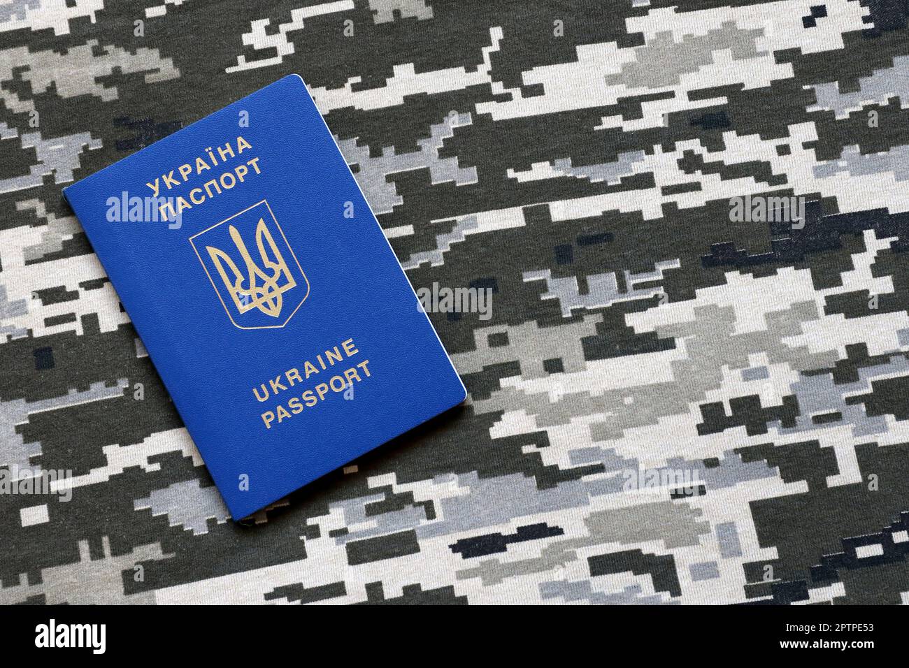 Ukrainian foreign passport on fabric with texture of military pixeled ...