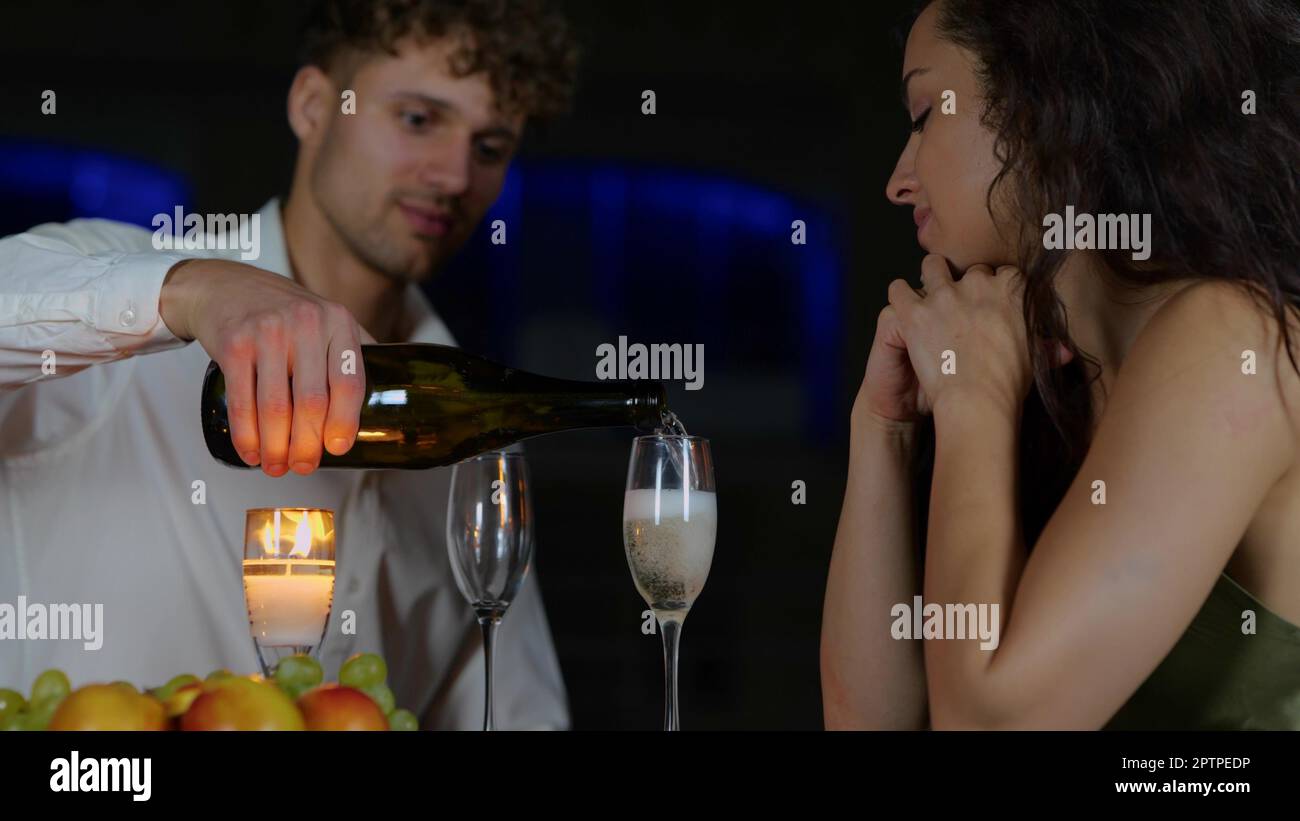 Camera moving back from young couple sitting at decorated table with ...