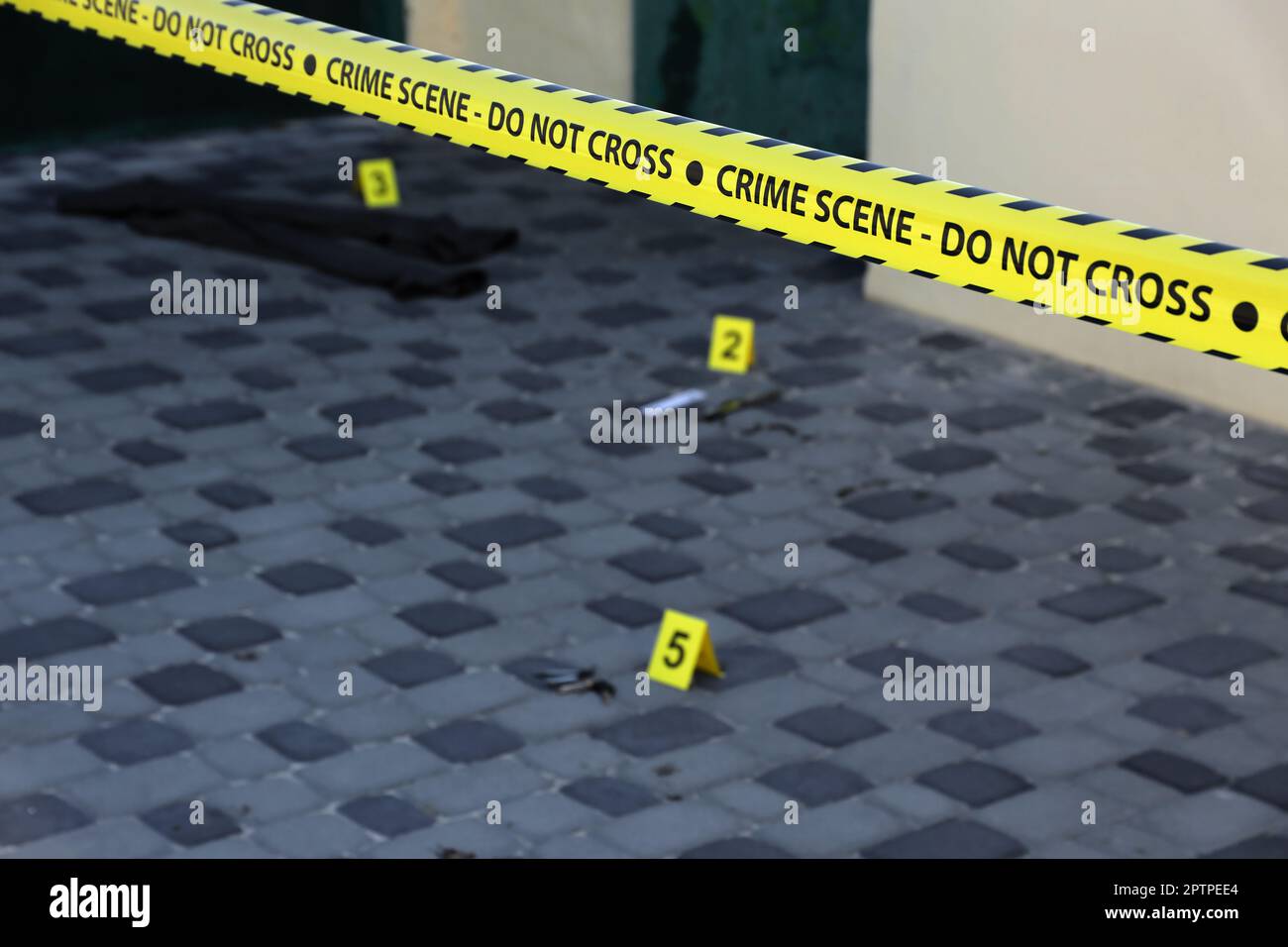 Crime scene tape for covering the area cordon. Yellow tape with blurred forensic law enforcement ...