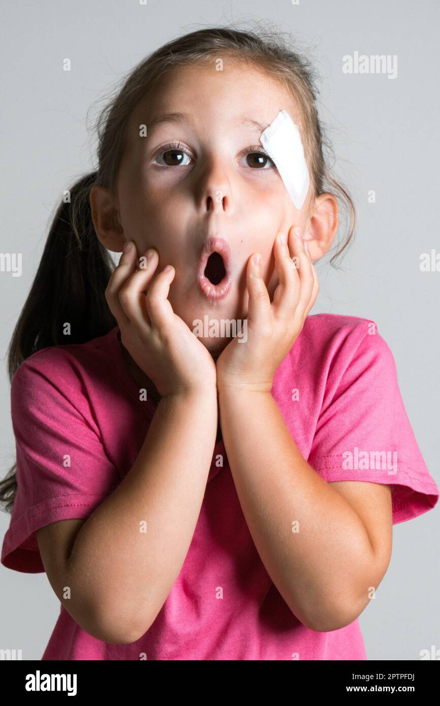 Close up funny, adorable dark haired little girl with injury and patch ...