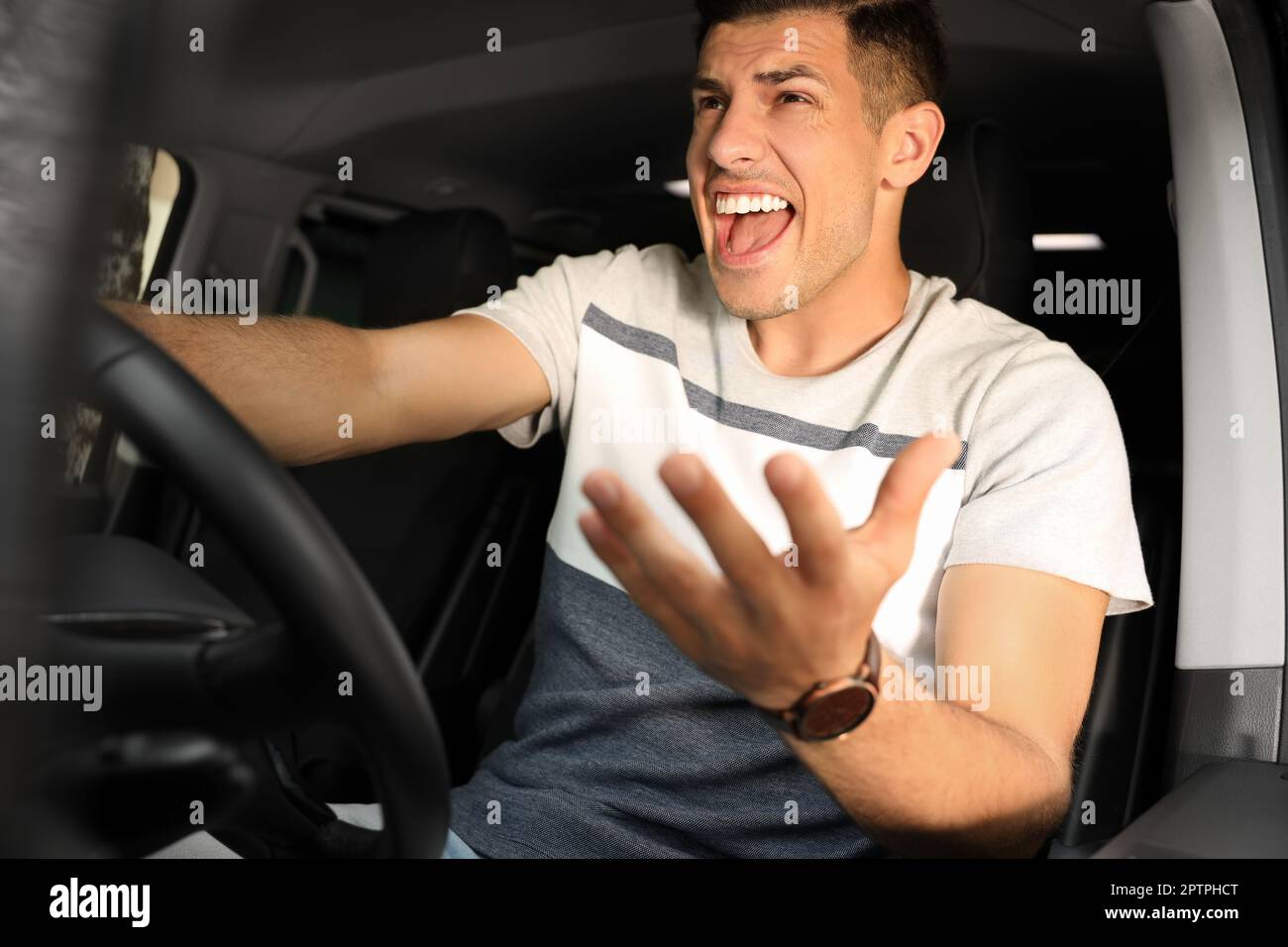 Emotional man yelling in car. Aggressive driving behavior Stock Photo ...