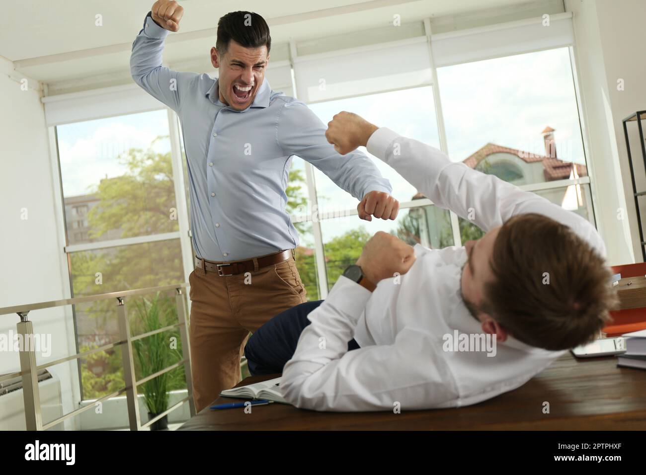 Emotional colleagues fighting in office. Workplace conflict Stock Photo ...