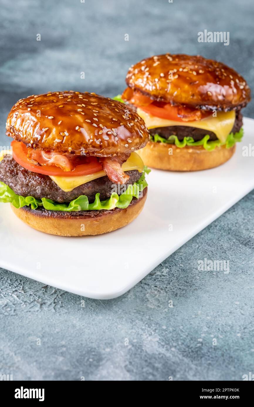Two hamburgers on the plate close up Stock Photo - Alamy