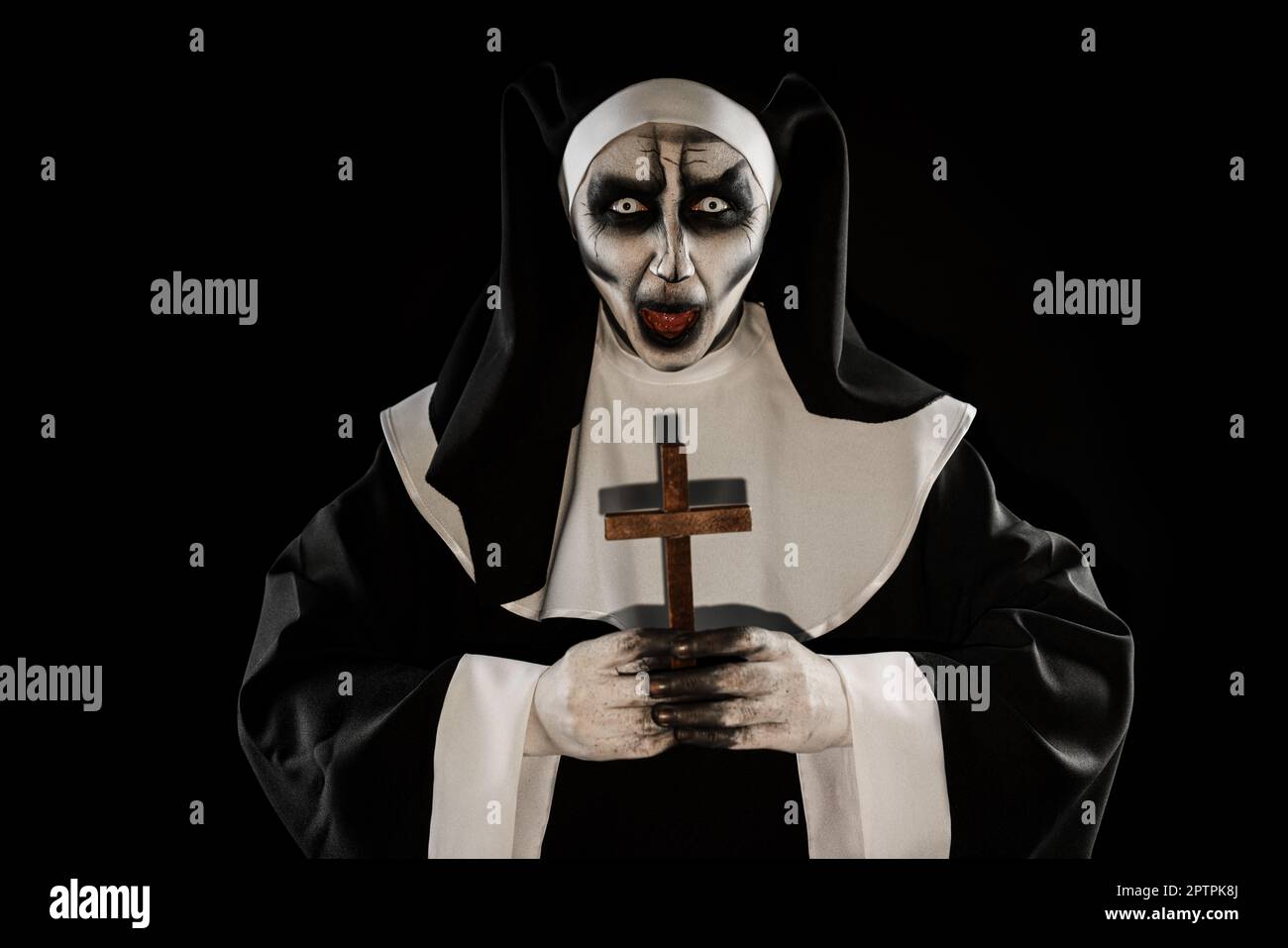 Scary devilish nun with cross on black background. Halloween party look ...