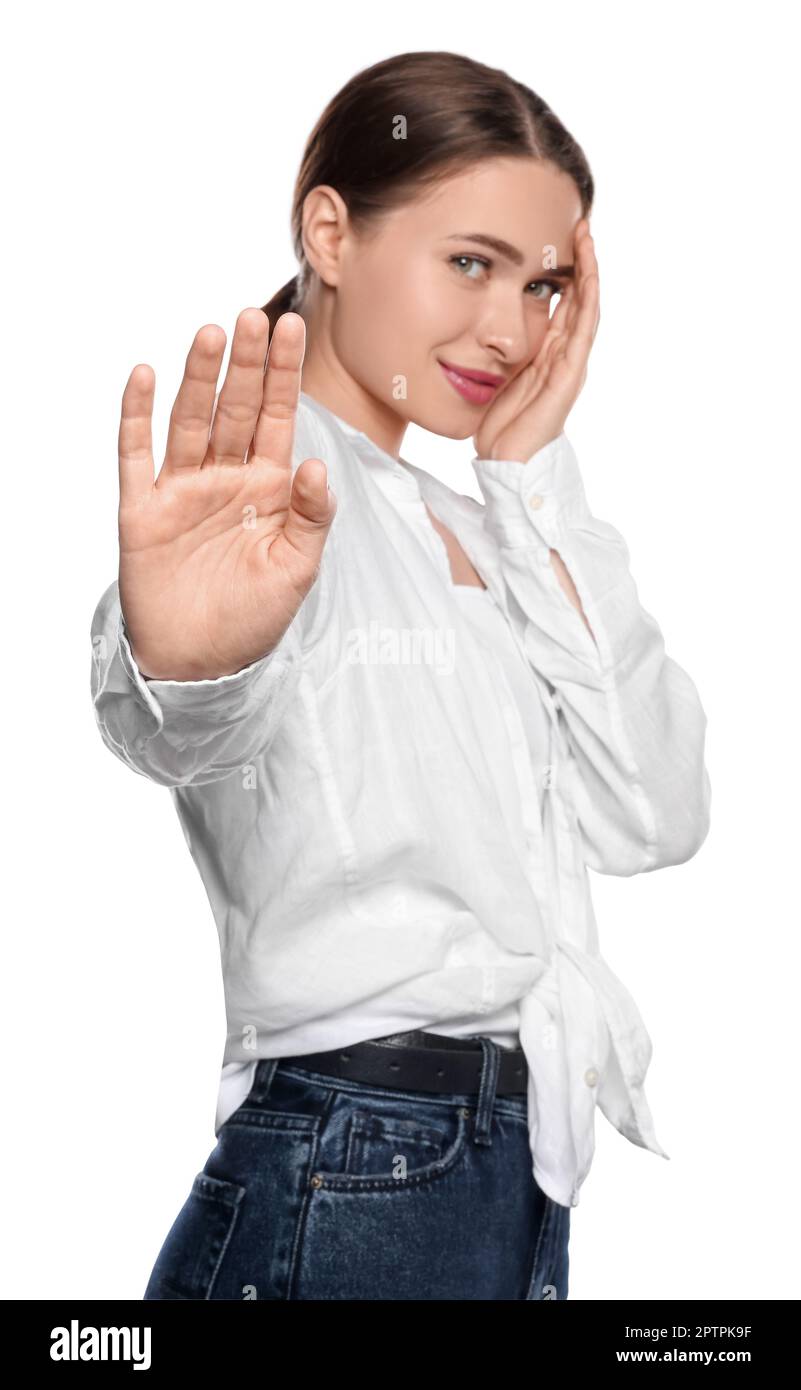 Embarrassed young woman covering face with hand on white background ...